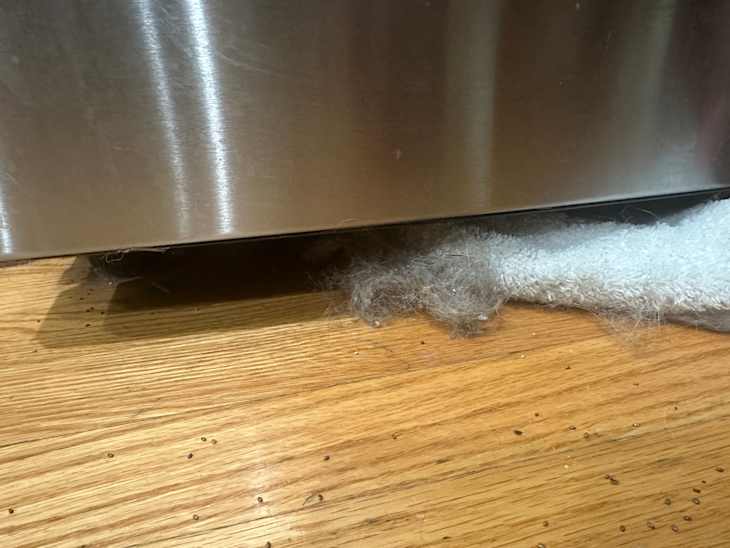 How to Clean Under Appliances with a Sock and a Clothes Hanger | The Kitchn