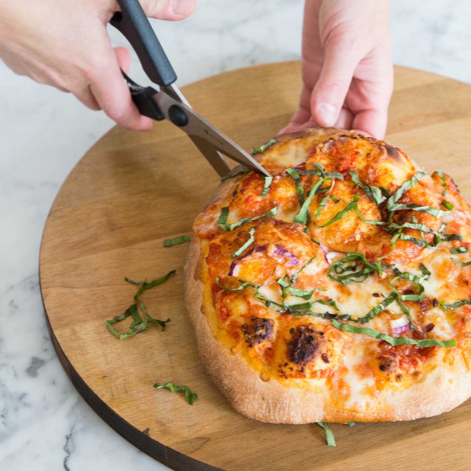 using scissors to cut pizza